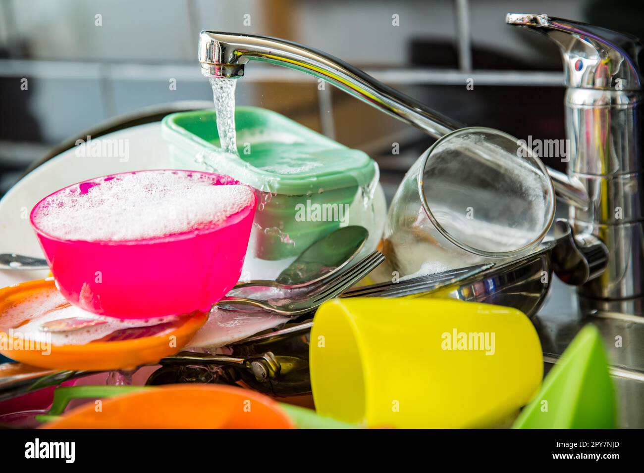 Kitchen sink full of dirty dishes. Dark colored countertop in modern ...