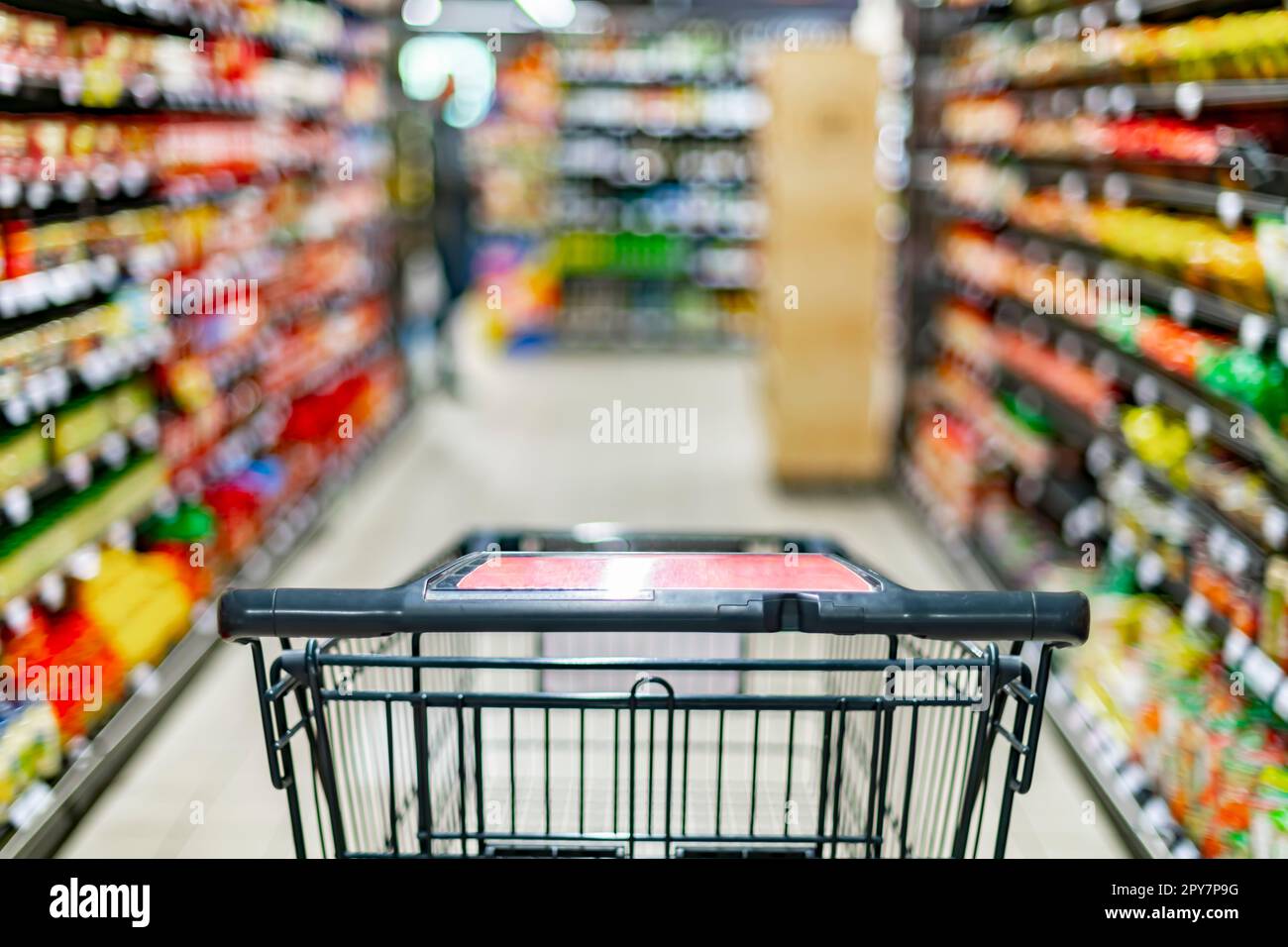 A shopping cart by a store shelf in a supermarket Stock Photo - Alamy