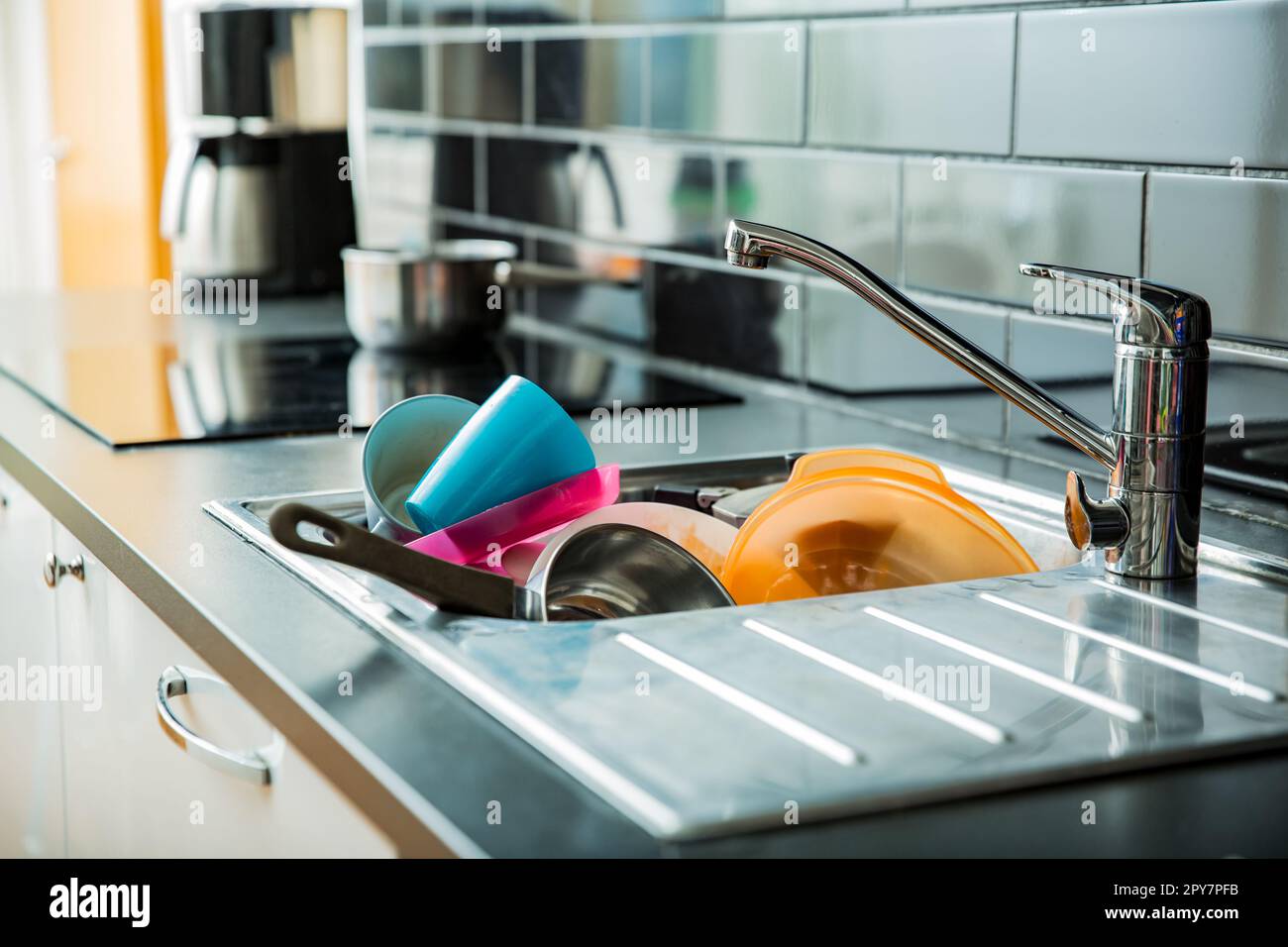 Kitchen sink full of dirty dishes. Dark colored countertop in modern ...