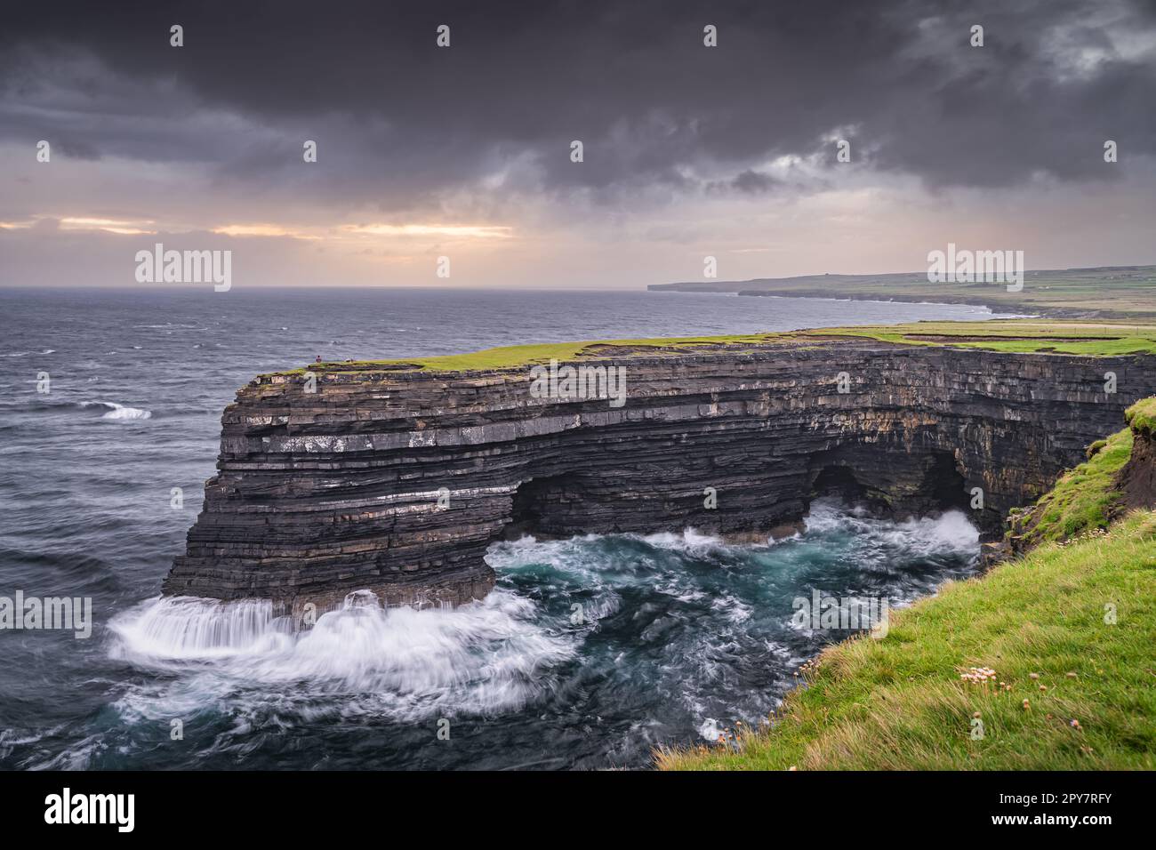Fisherman standing on the edge of Downpatrick Head cliffs at dawn ...