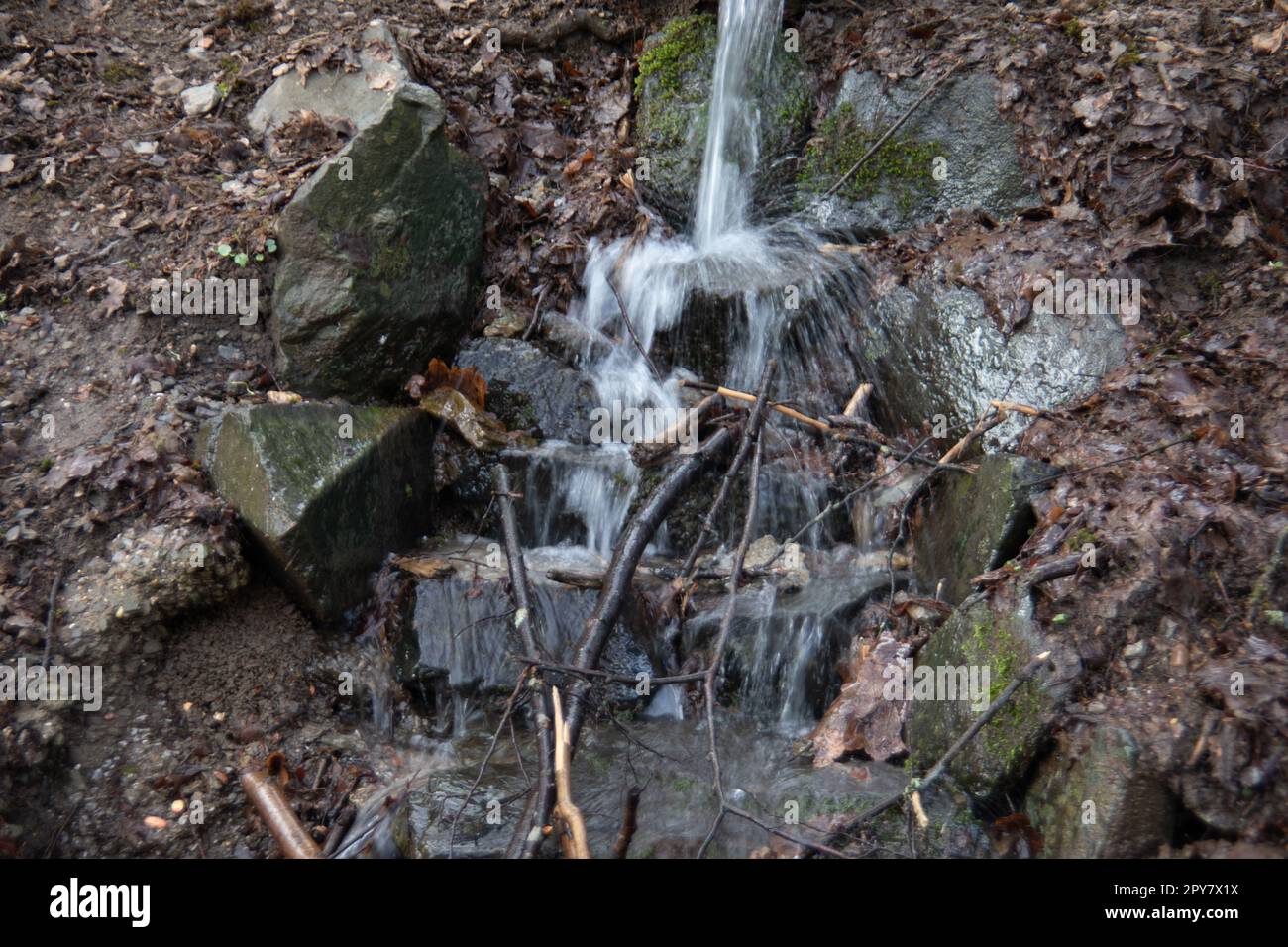 River course littered with rocks with waterfall in Siegerland Stock ...