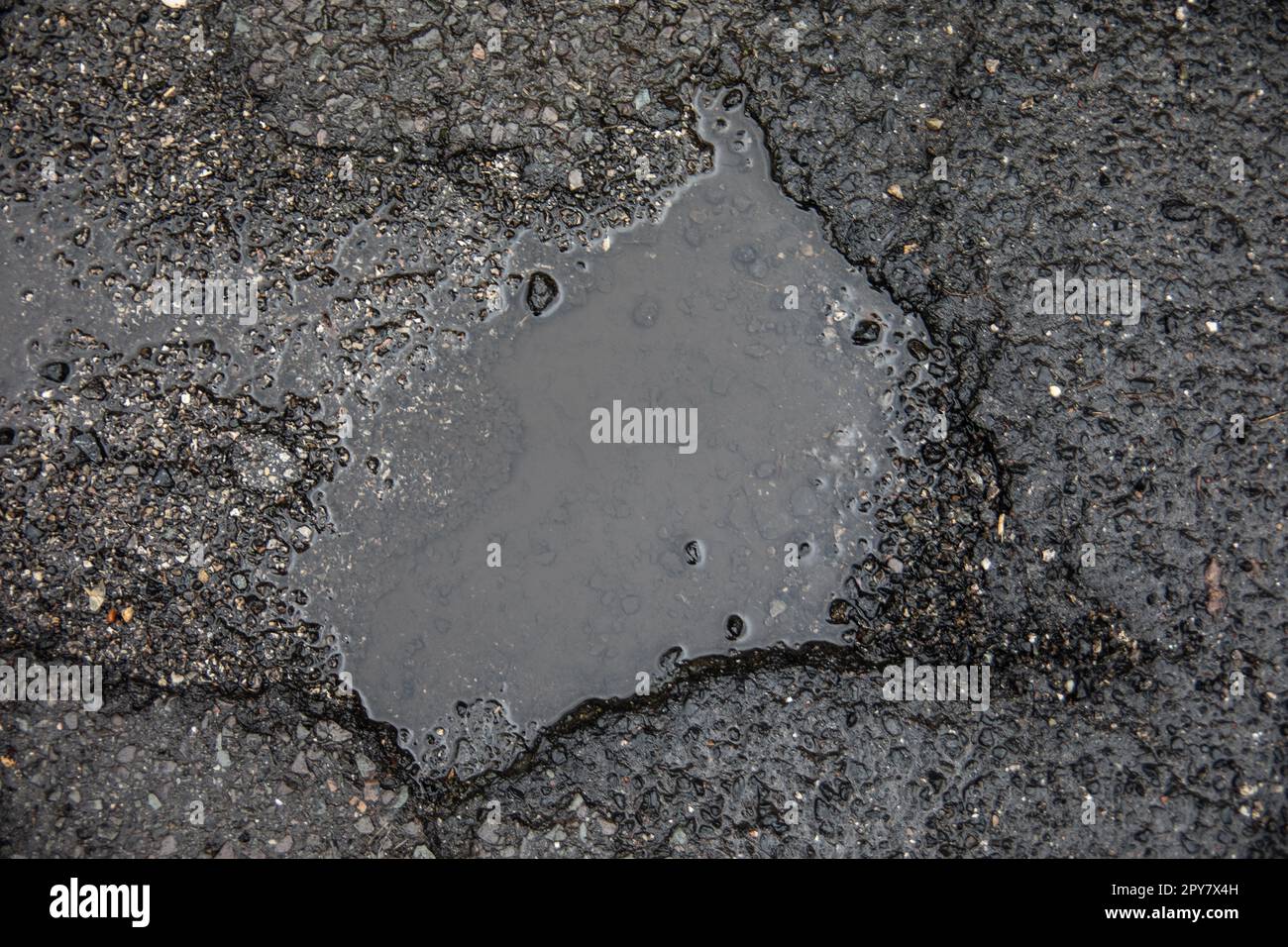 Road damage caused by potholes in the asphalt of the roadway Stock ...