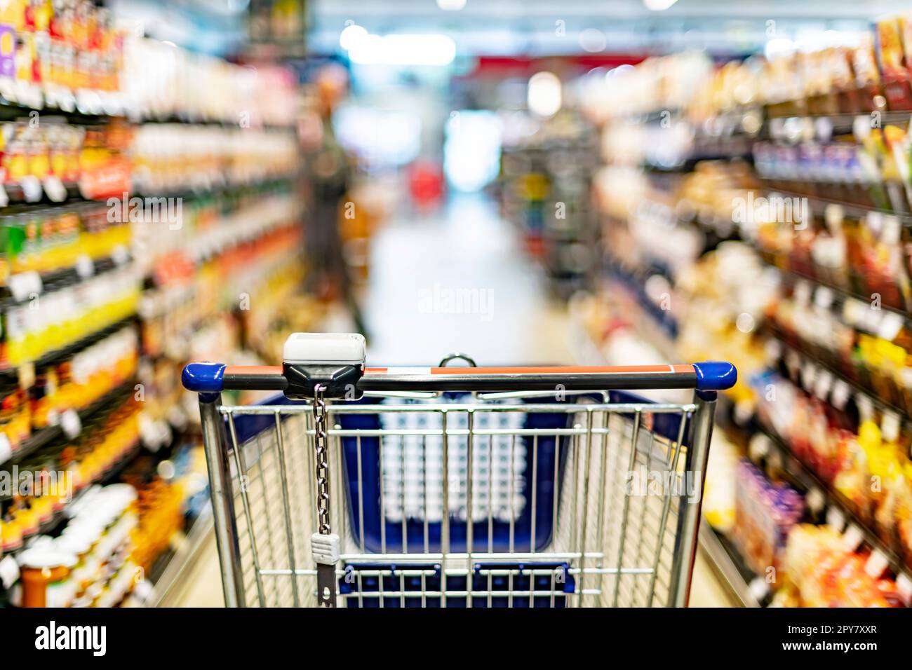 A shopping cart by a store shelf in a supermarket Stock Photo - Alamy