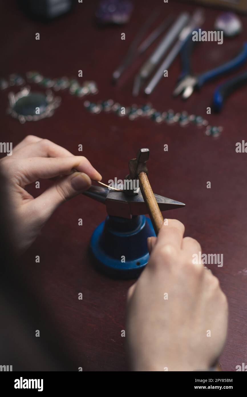 Close up jewelry hammer and tiny anvil concept photo. Woman at work ...