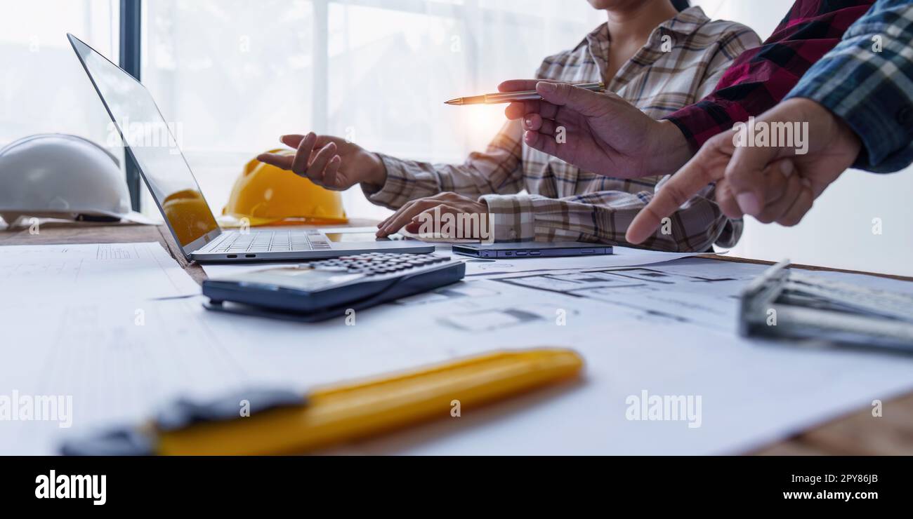 Architect and Engineer working with blueprints for architectural plan ...