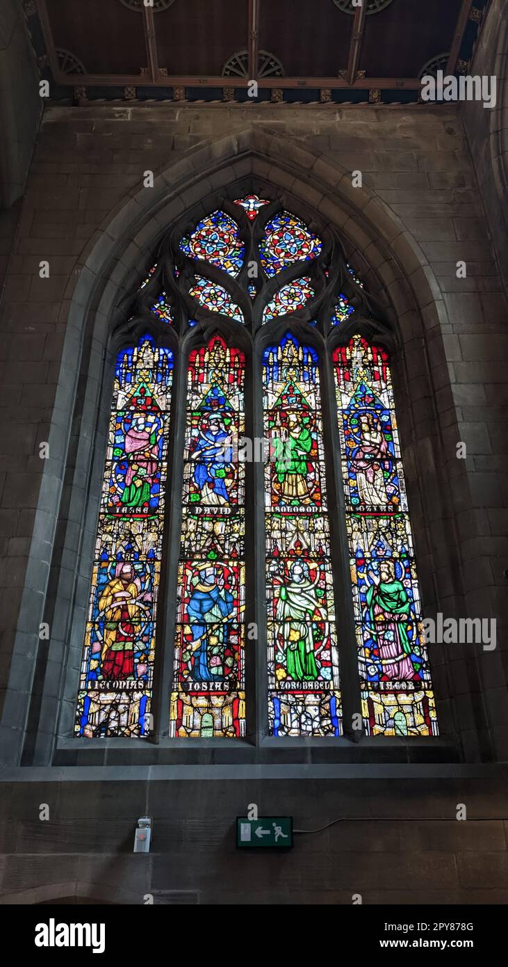a colorful vintage stained glass window with paintings of saints in a ...