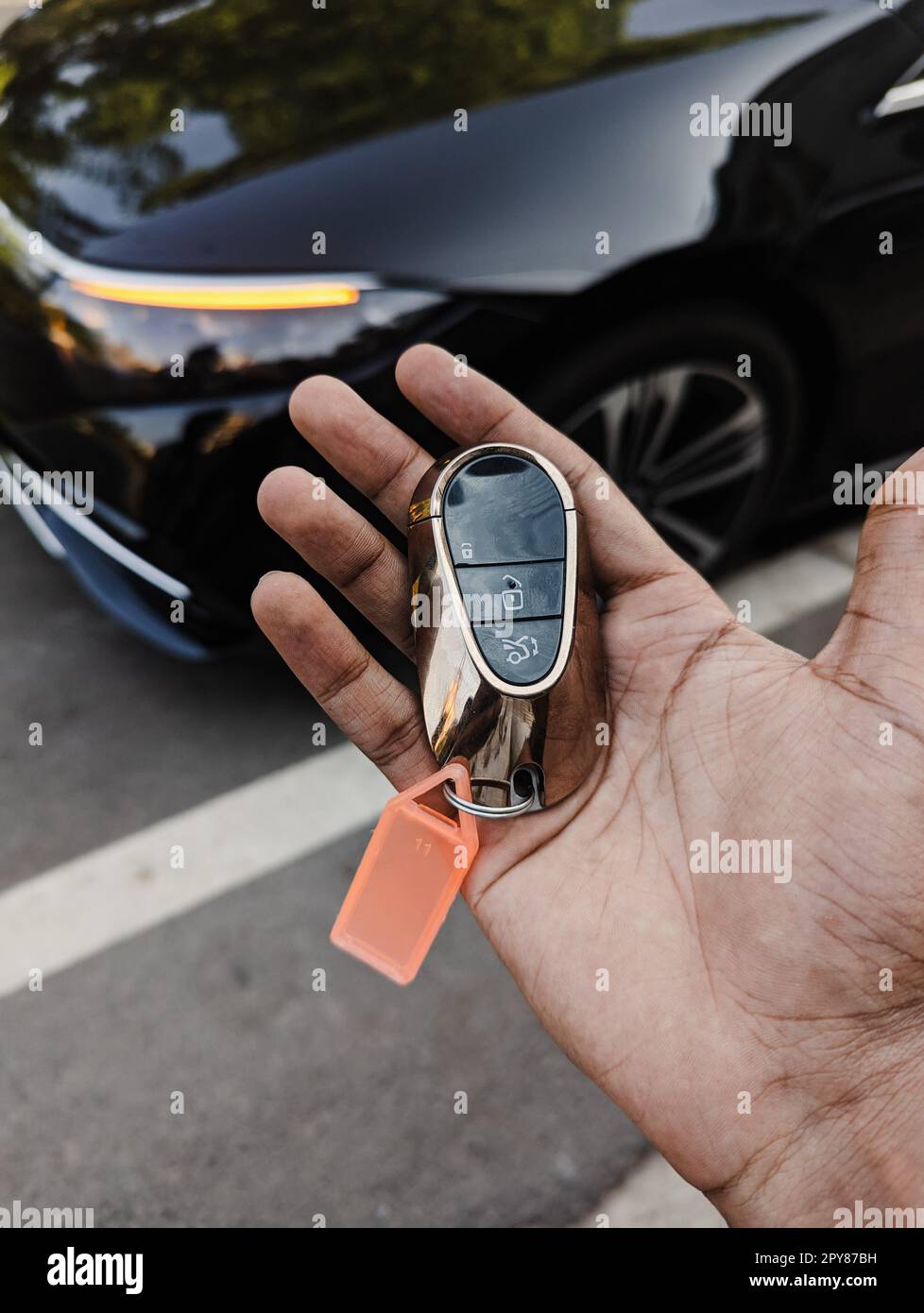 a modern electronic wireless car key with futuristic design in palm of ...
