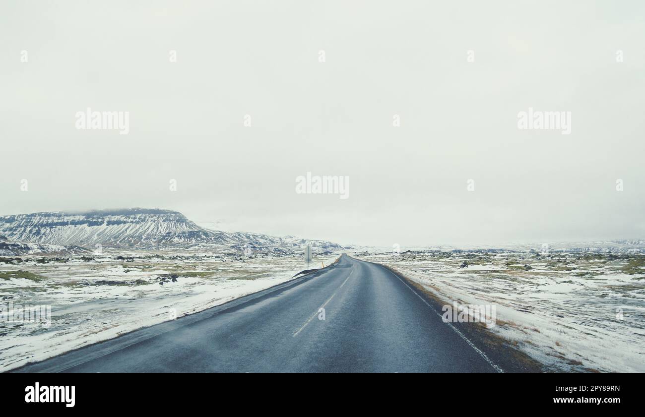 Empty road across snowy field landscape photo Stock Photo - Alamy