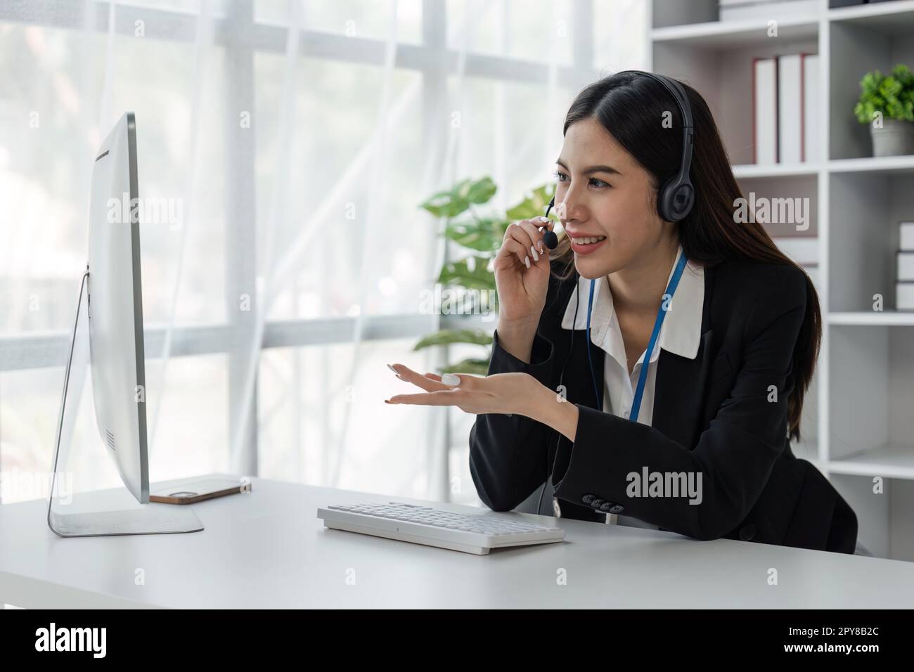 female operator working on computer and while talking with clients ...
