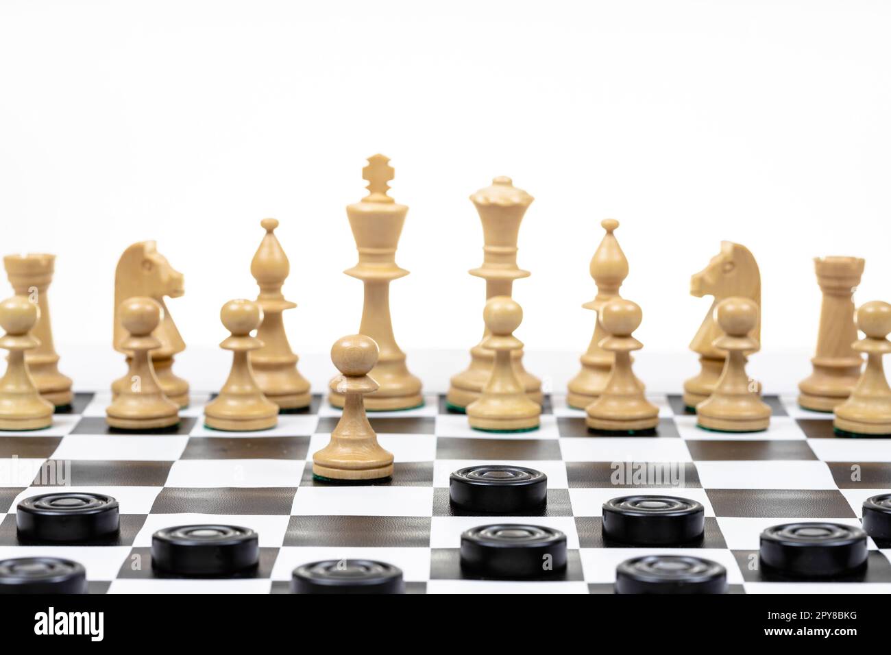 black checkers disc attacks white chess pawn Stock Photo - Alamy