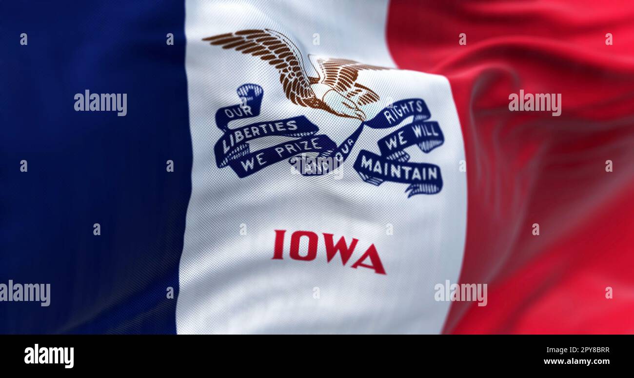 Detail of the Iowa state flag waving. Three vertical stripes of blue ...