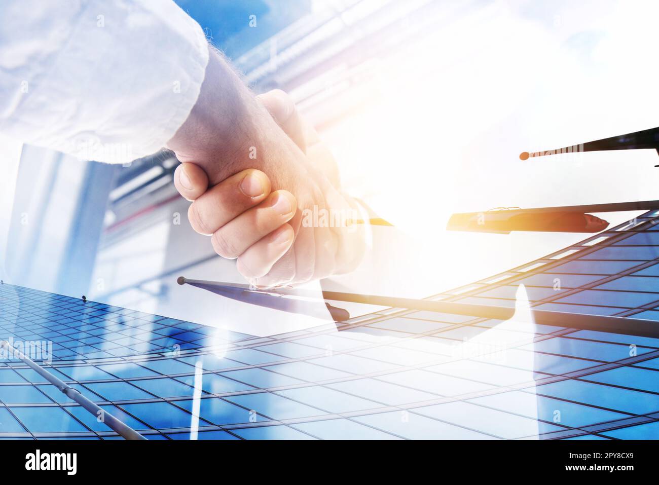 Two businessmen shake hands in agreement. Double exposure with light ...