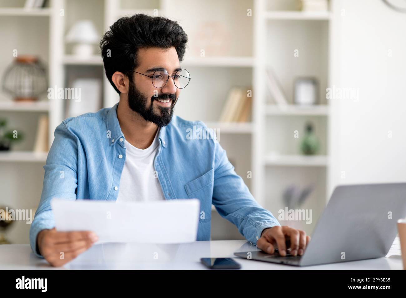 Indian Man Working With Papers And Laptop At Home Office Stock Photo ...
