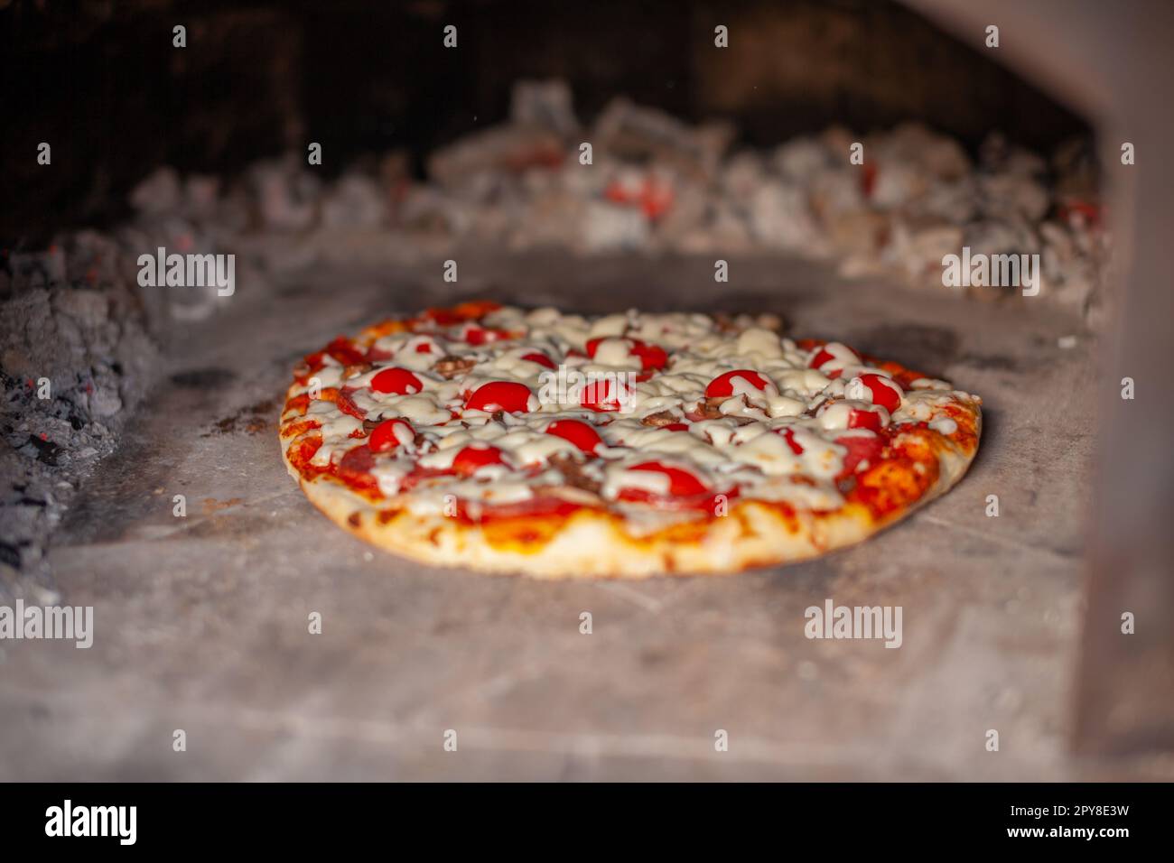 Cooking real pizza in a brick oven. Wood and fire are burning in the ...