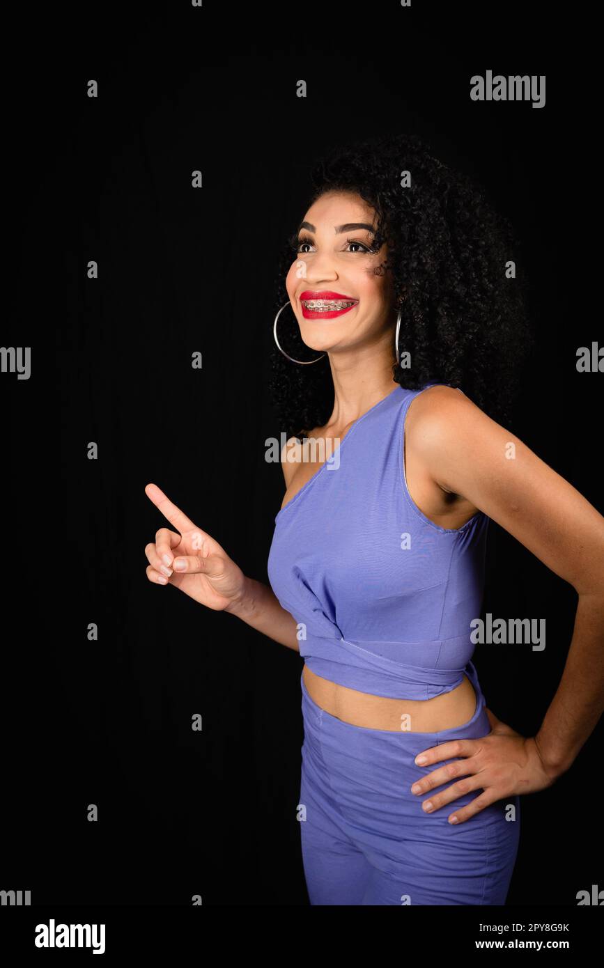 Portrait of young beautiful smiling woman pointing up. wearing blue ...