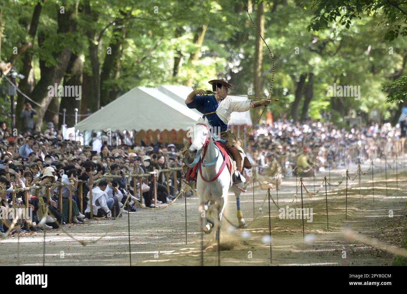 An archer shoots an arrow while riding a horse during the "Yabusame ...