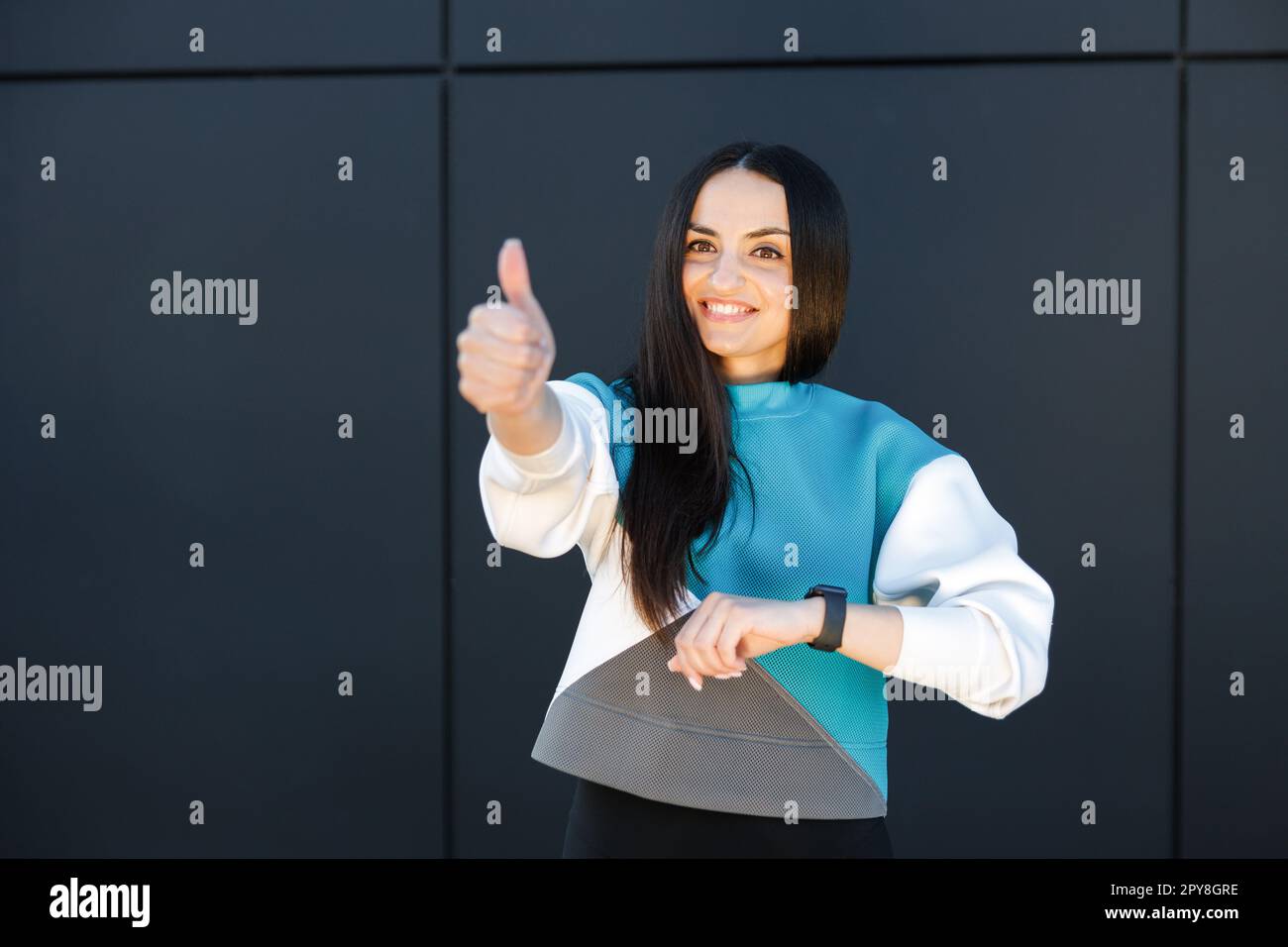 Cute sporty girl smiling cutely and showing good job gesture while ...