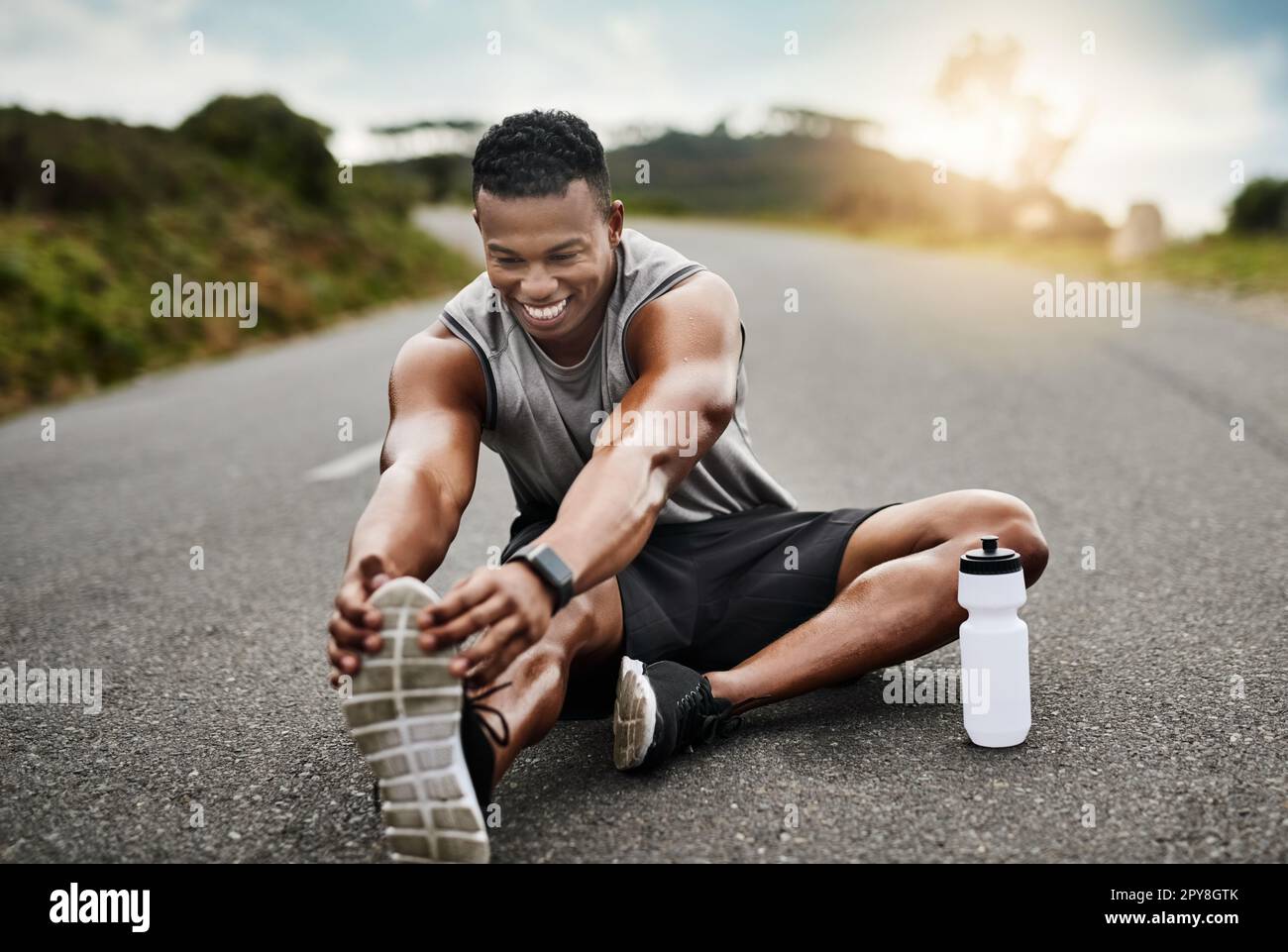 Its time to wake up these leg muscles. a sporty young man stretching ...