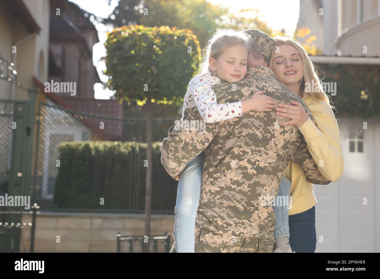 Daughter and wife hugging soldier in Ukrainian military uniform ...
