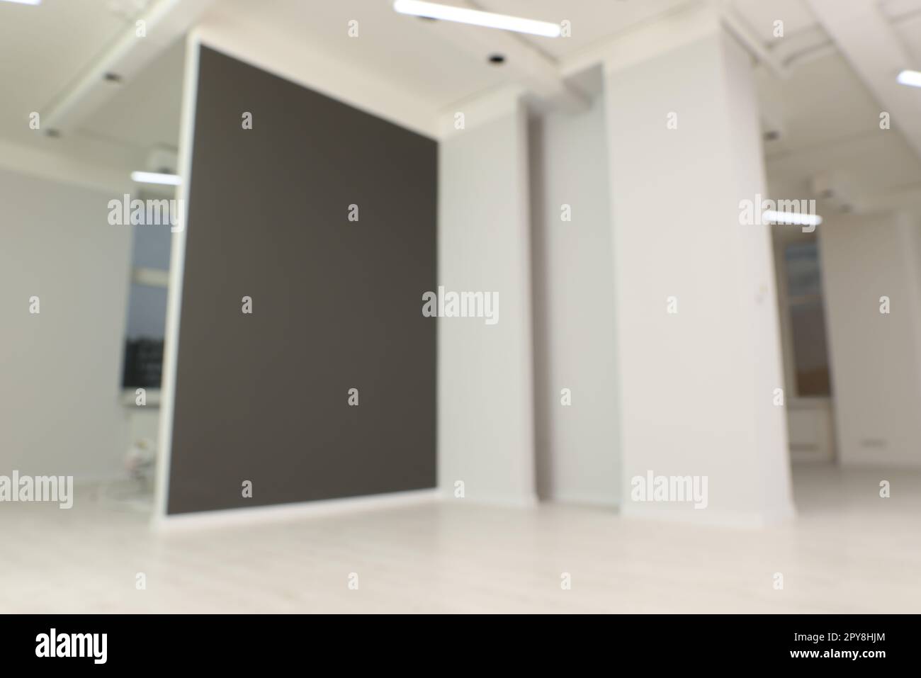 Blurred view of empty office room with color walls and modern lights on ...