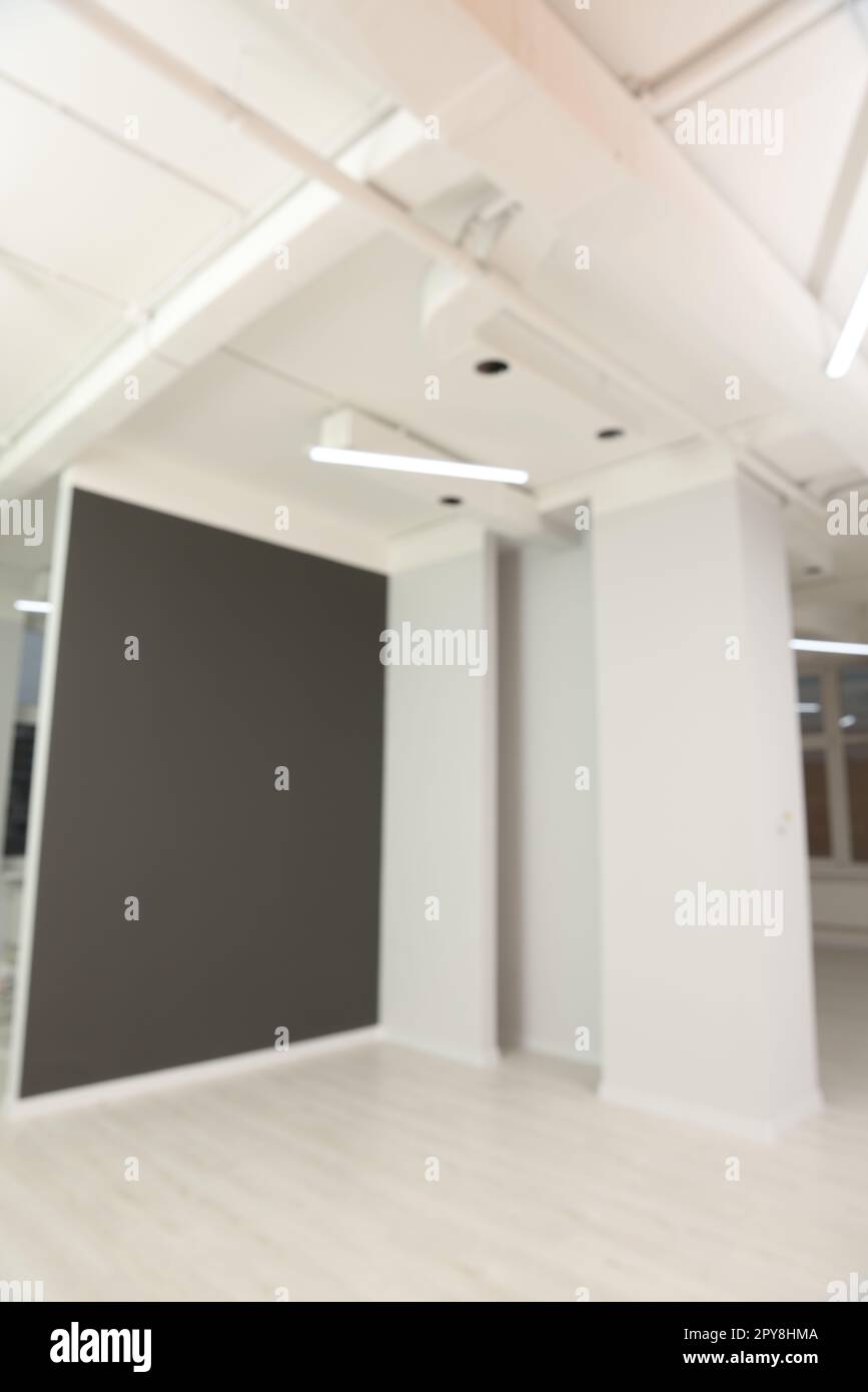 Blurred view of empty office room with color walls and modern lights on ...