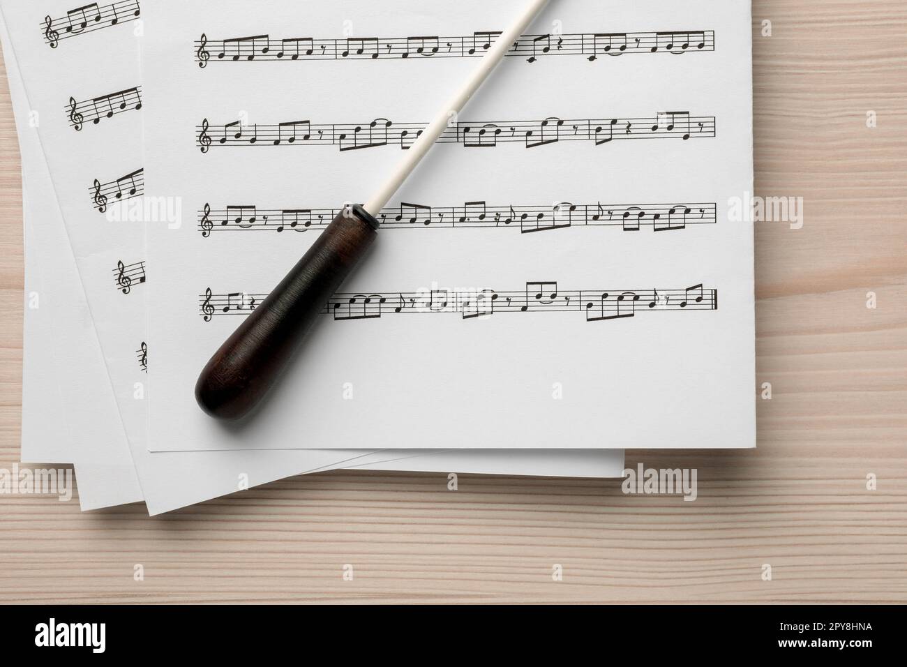 Conductor's baton and sheet music on white wooden table, top view Stock ...