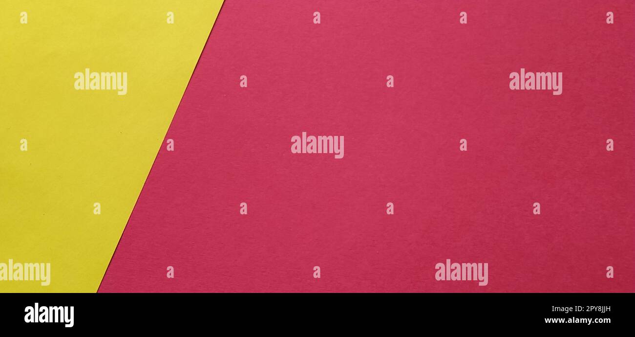 A yellow sheet of paper is laid sideways on a red sheet of paper. Thick ...