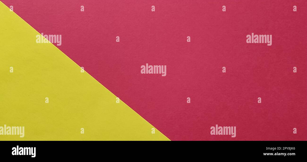 A yellow sheet of paper is laid sideways on a red sheet of paper. Thick ...