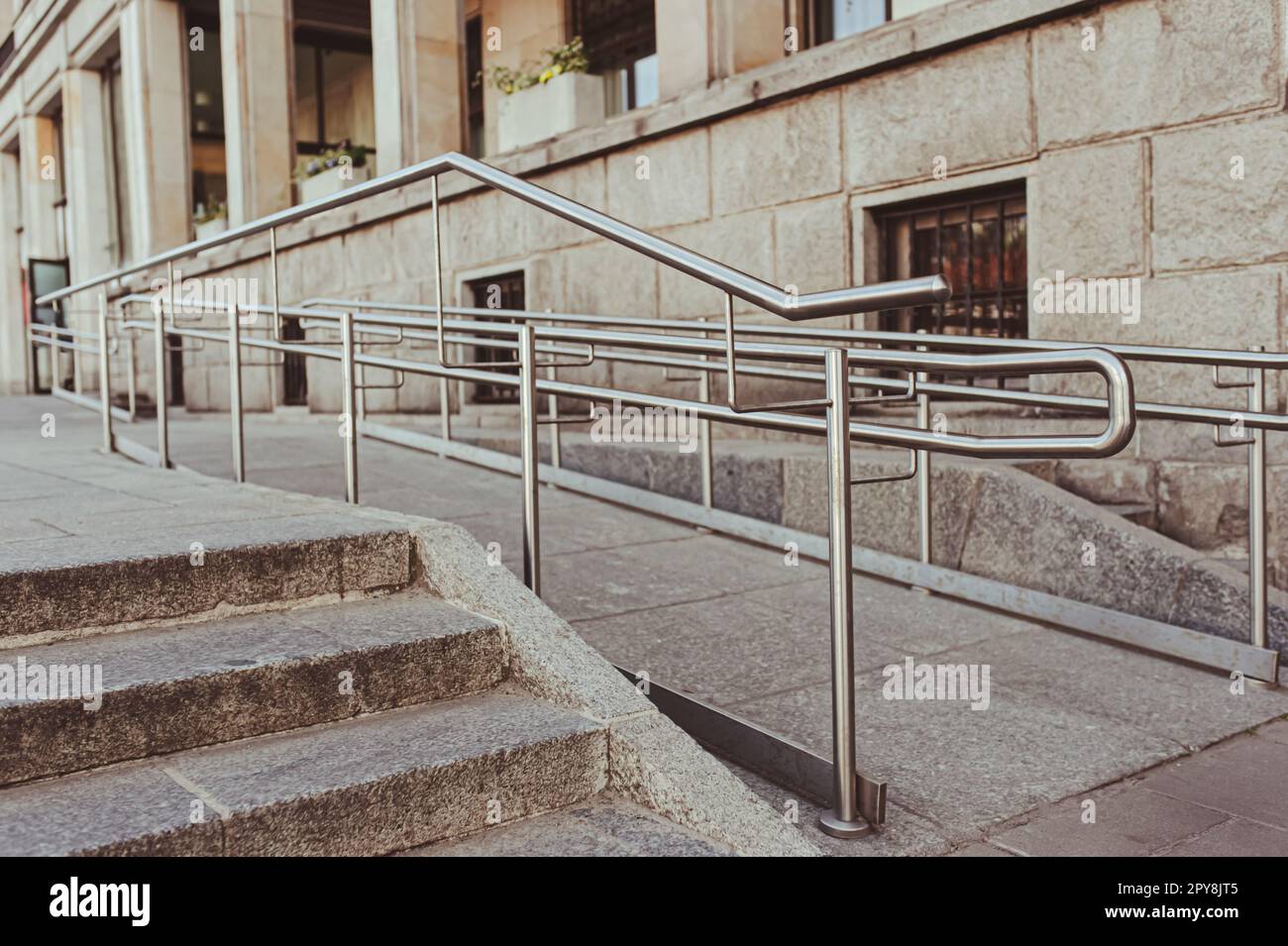 Tiled ramp with shiny metal railings outdoors Stock Photo - Alamy