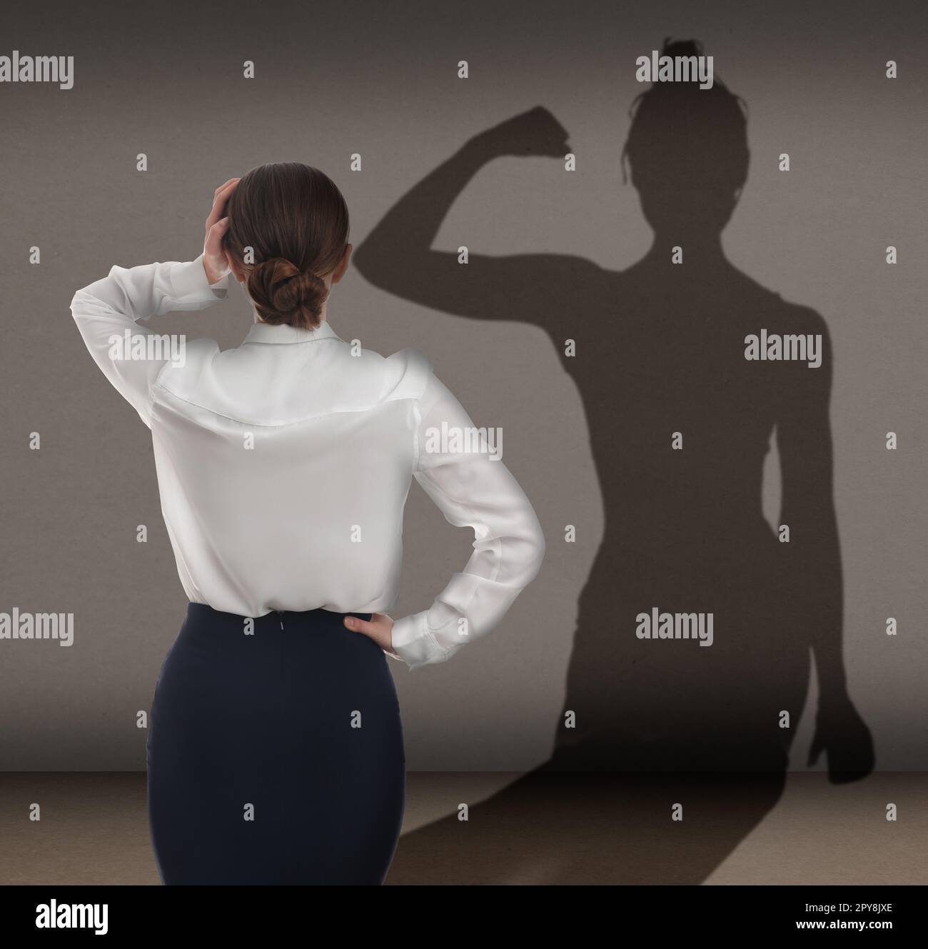 Businesswoman and shadow of strong muscular lady in front of her on ...