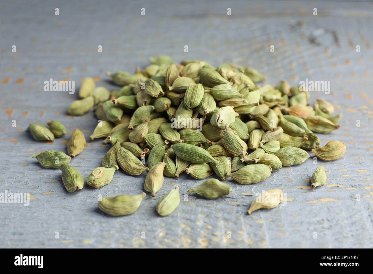 Pile of dry cardamom pods on grey wooden table Stock Photo - Alamy