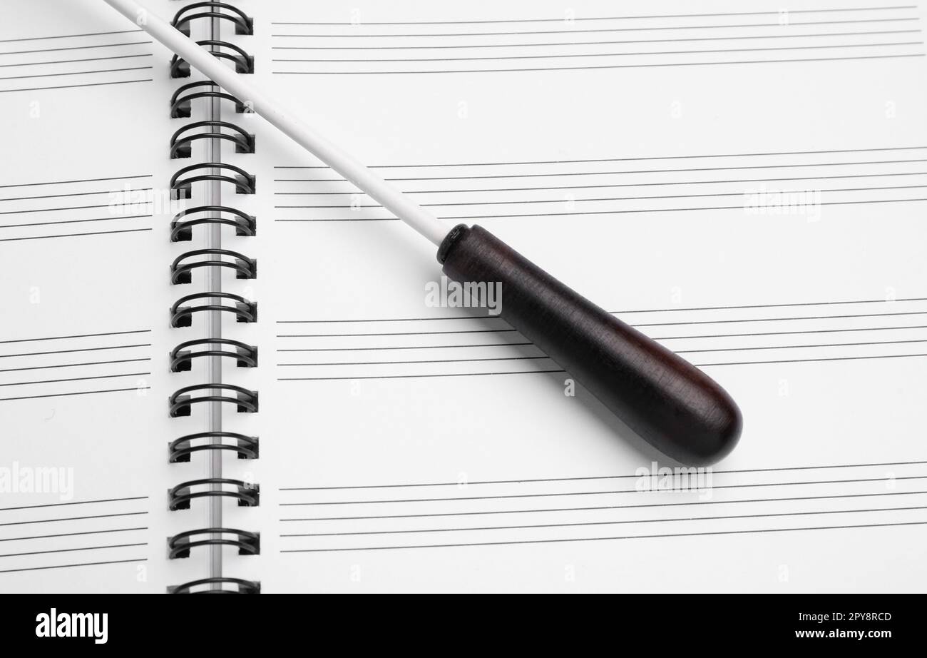 Conductor's baton on sheet music book , above view Stock Photo - Alamy