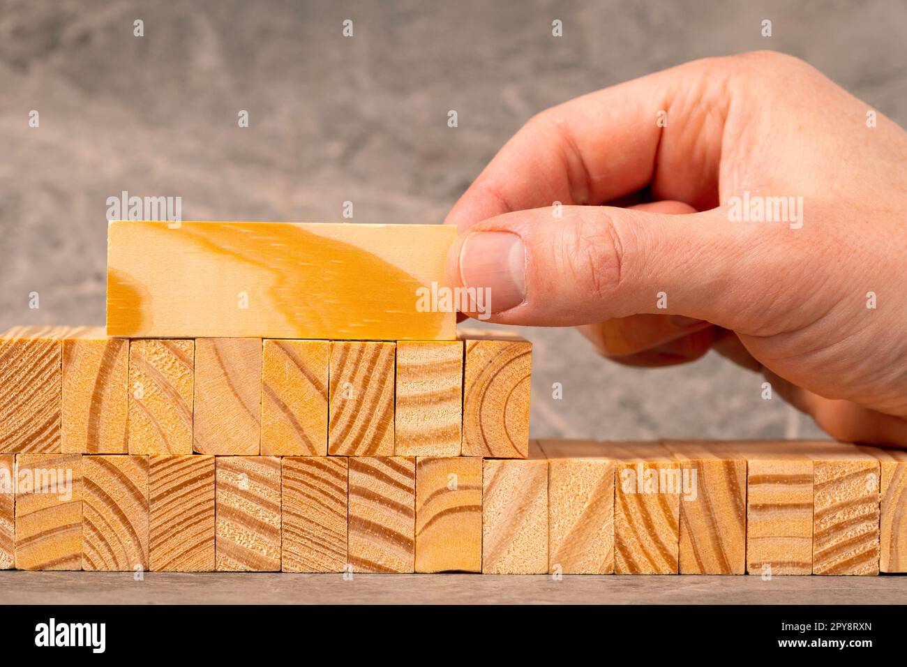 Hand stacking wooden blocks Stock Photo - Alamy