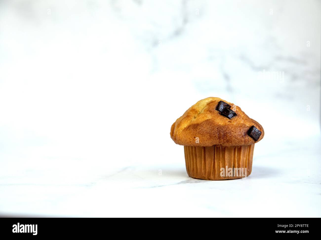 A stack of delicious chocolatechip banana muffins and blueberries on a ...