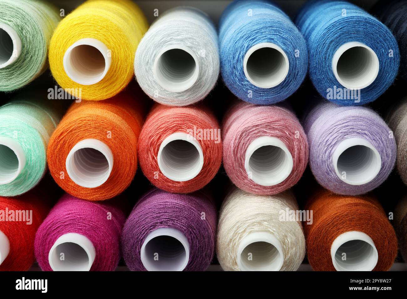 Set of different colorful sewing threads as background, above view ...
