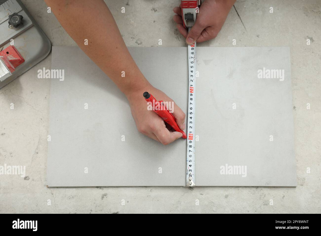 Worker measuring and marking ceramic tile on floor, closeup Stock Photo ...
