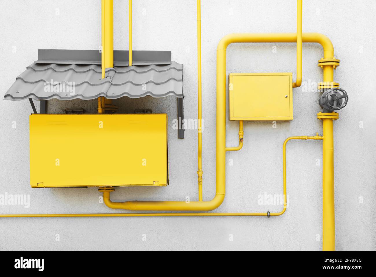 Gas meter box and pipes near grey wall outdoors Stock Photo - Alamy
