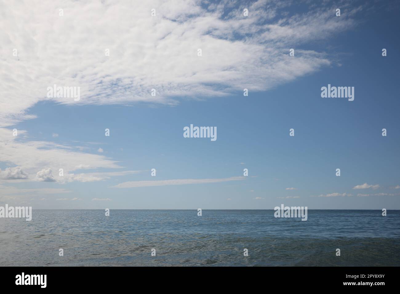 Picturesque view of sea under beautiful blue sky with fluffy clouds ...