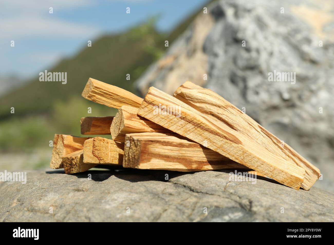Many palo santo sticks on stone surface in high mountains, closeup ...