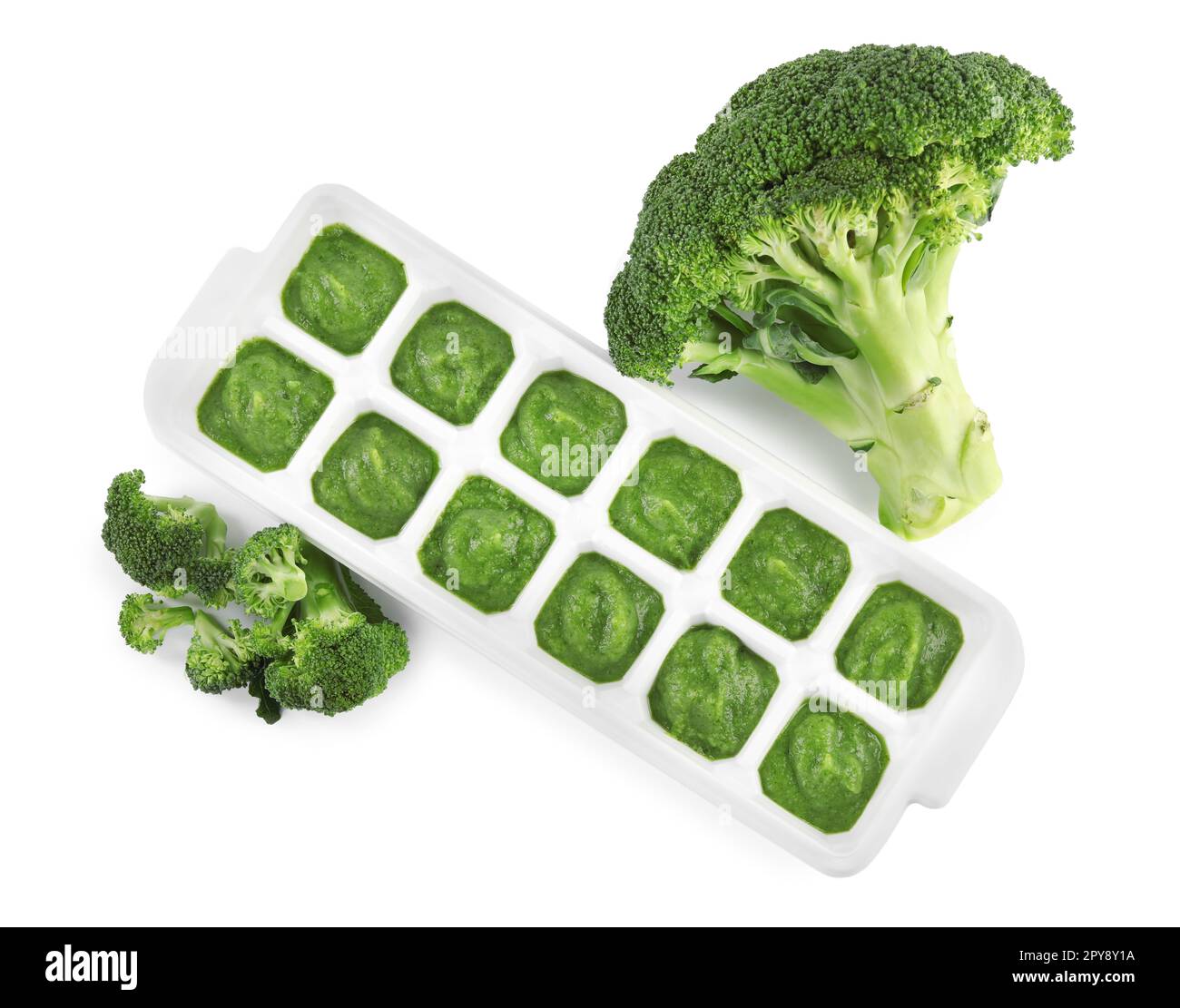 Broccoli puree in ice cube tray and ingredients on white background ...