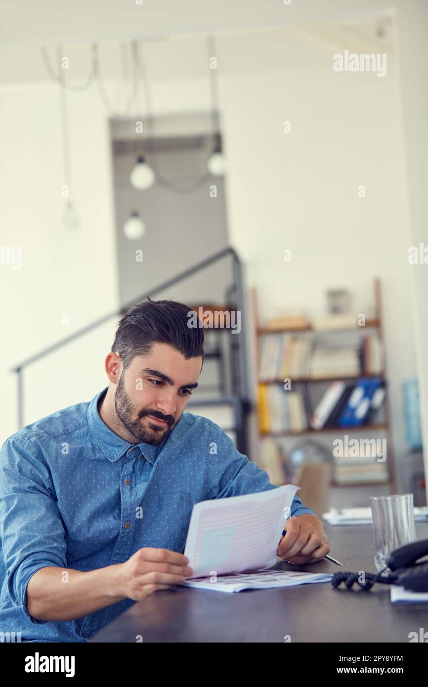 Call him the paperwork king. a young businessman working through ...