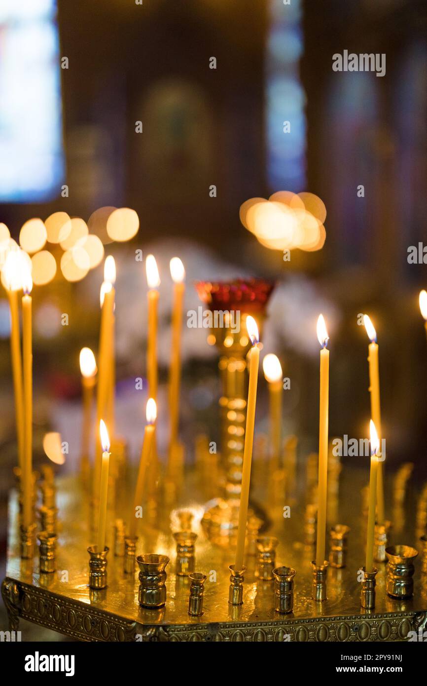 Burning wax candles in candlesticks in the Orthodox Church. Image with ...
