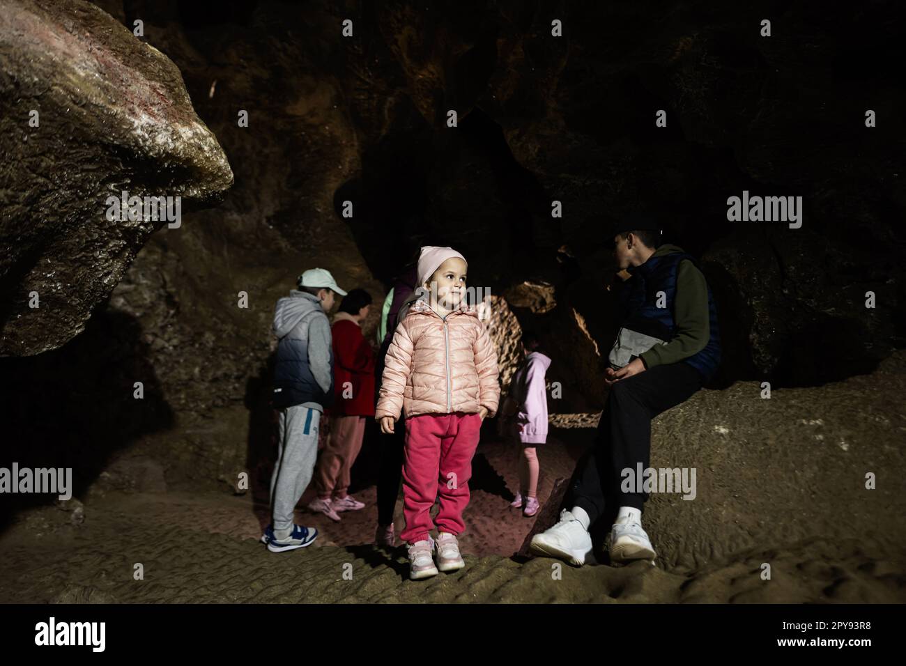 Family tourists walking in cave and explore it Stock Photo - Alamy