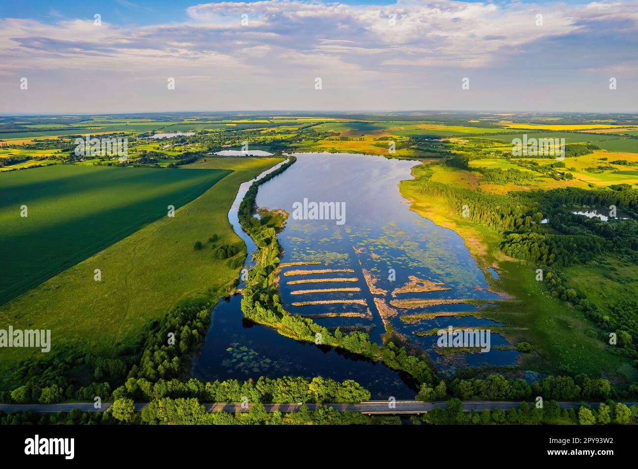 Aerial view of wide river flowing quietly in rural countryside between ...
