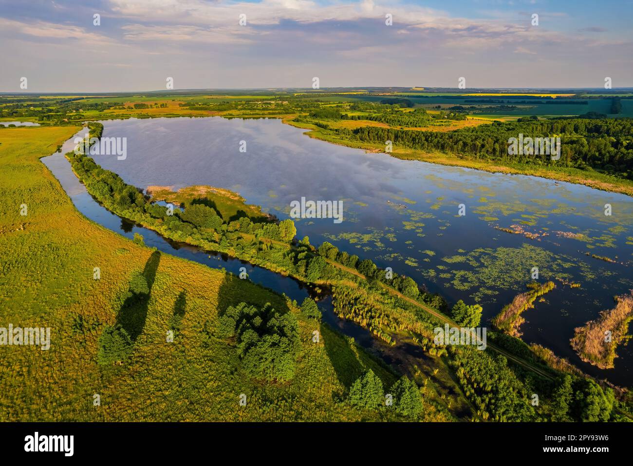 Aerial view of wide river flowing quietly in rural countryside between ...