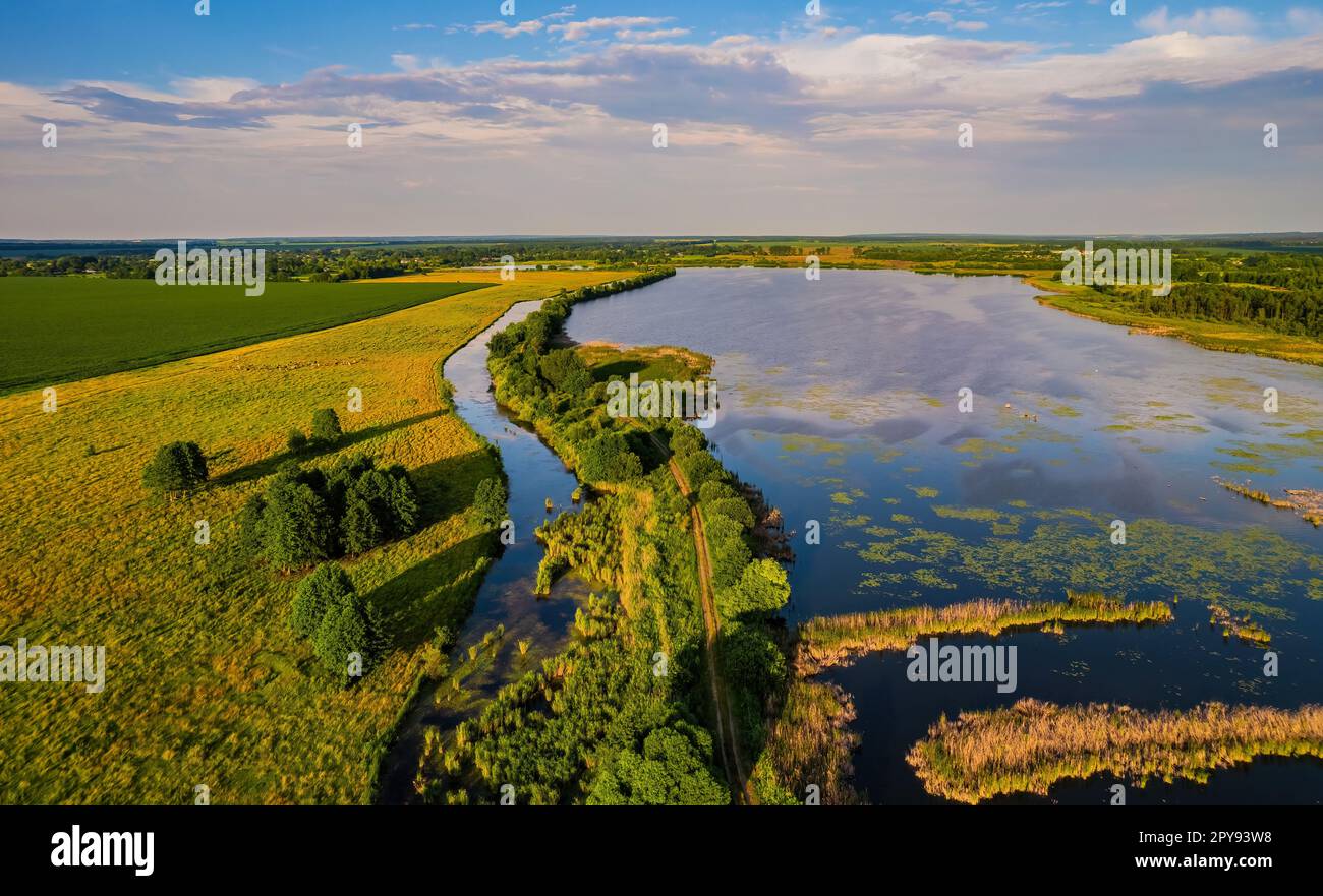 Aerial view of wide river flowing quietly in rural countryside between ...