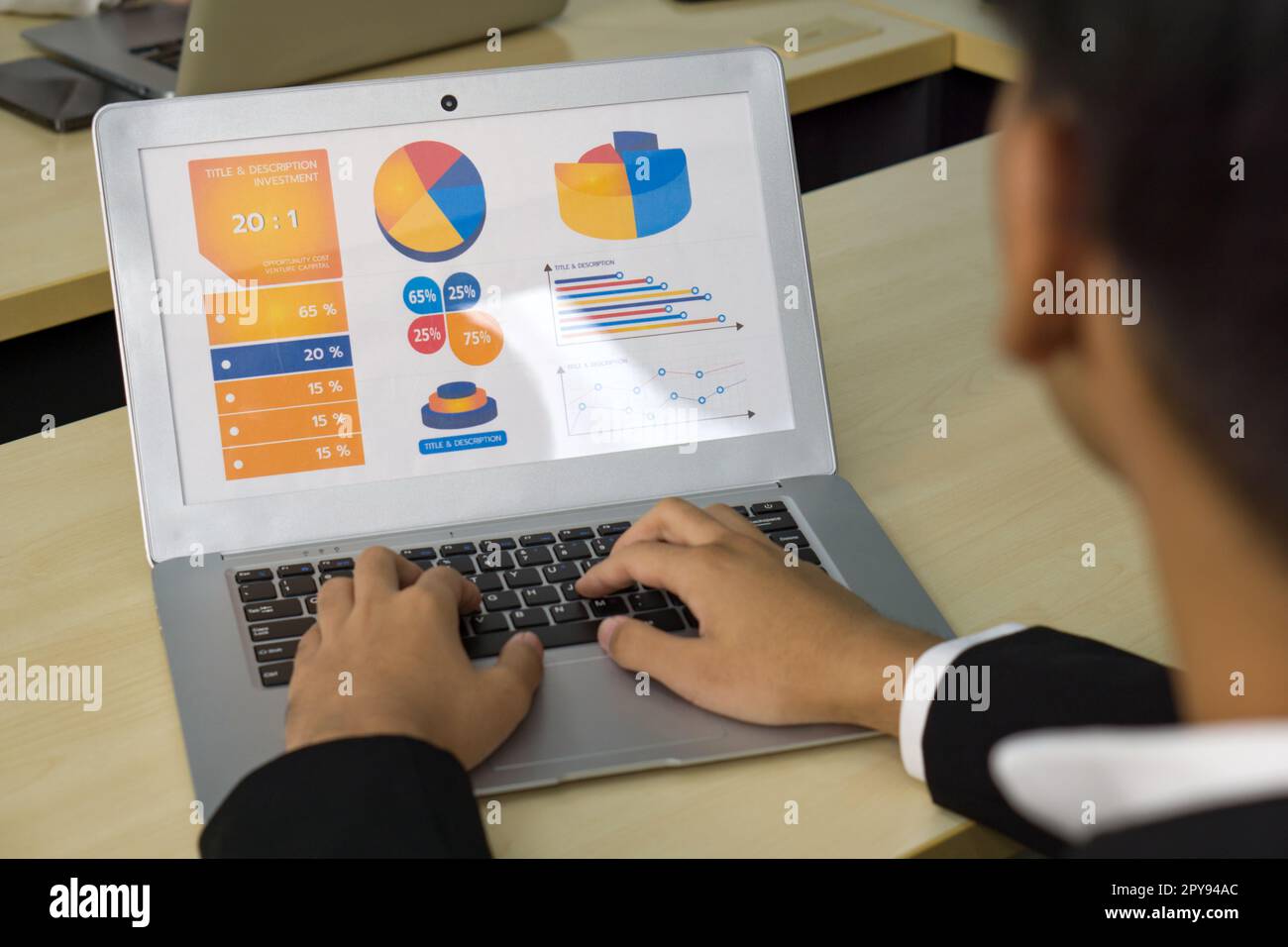 Back view of businessman in suit sit at desk in office typing on laptop ...