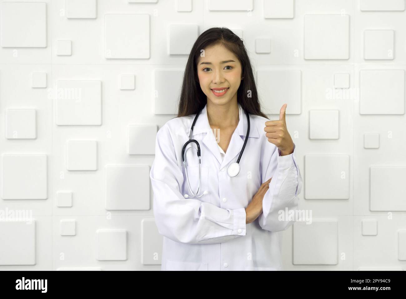Young asian doctor in white gown and stethoscope stand with finger ...