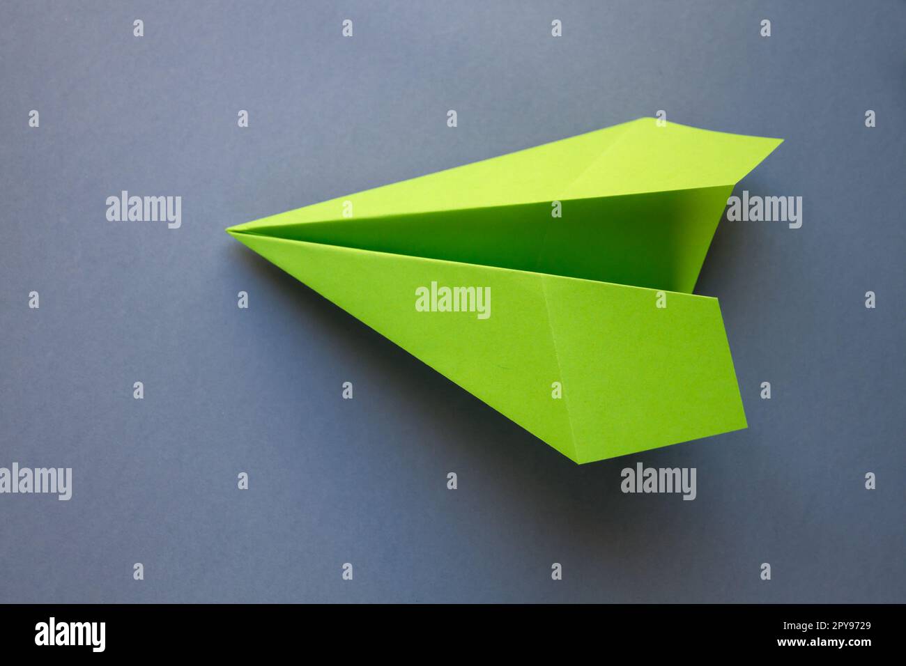 Green paper plane origami isolated on a grey background Stock Photo - Alamy