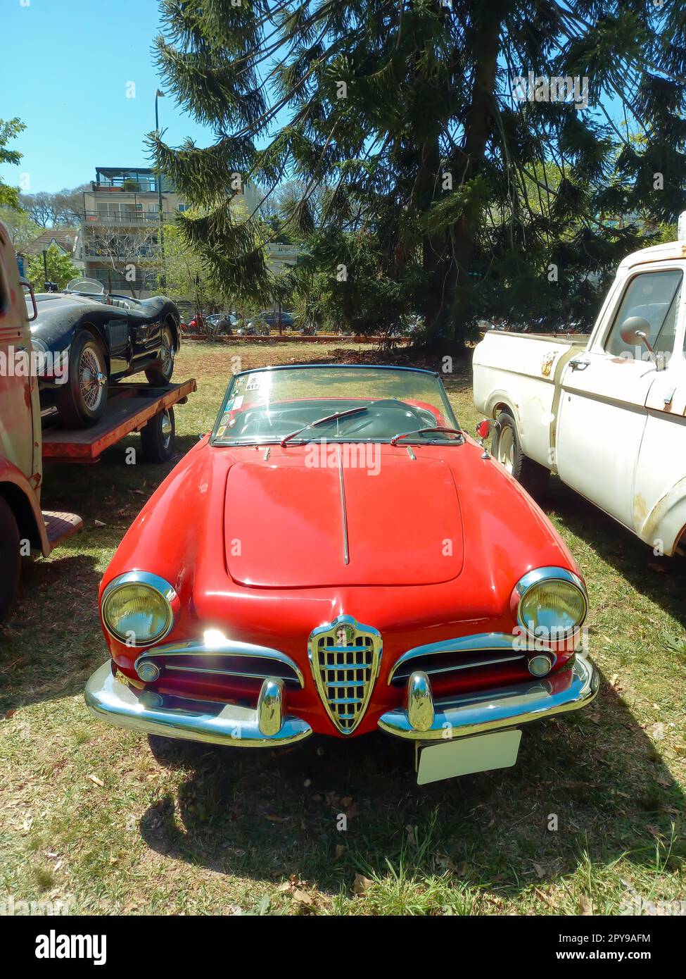 Old red sport Alfa Romeo Giulietta Spider roadster circa 1960 in a park ...